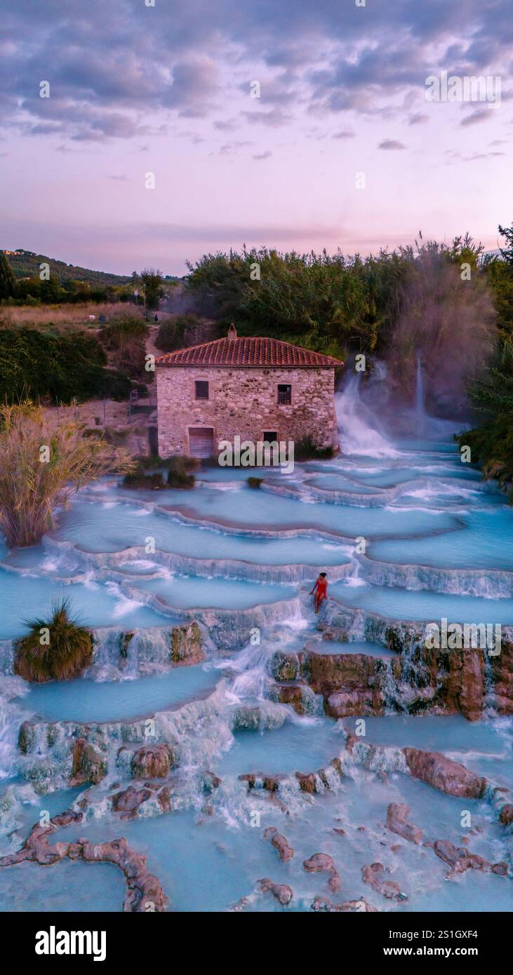 Visitors enjoy the soothing waters of Saturnia thermal baths under a ...