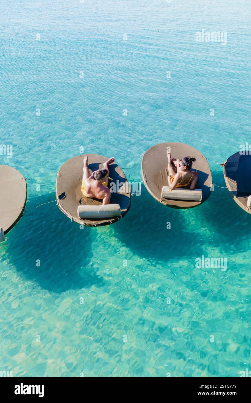 Golden sunlight dances on the tranquil surface as visitors unwind on ...