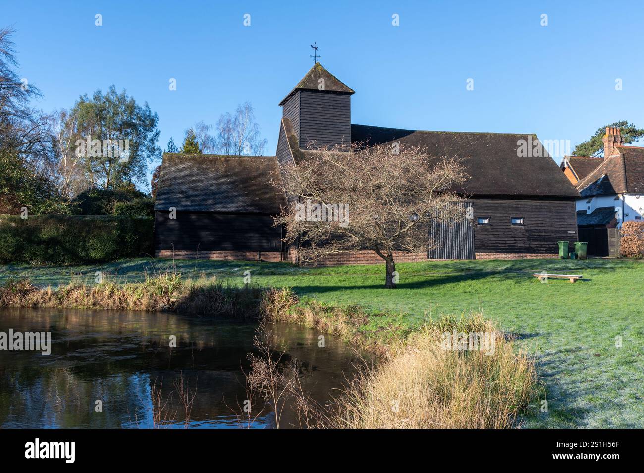 The historic Towered Barn and village pond beside the village green in ...