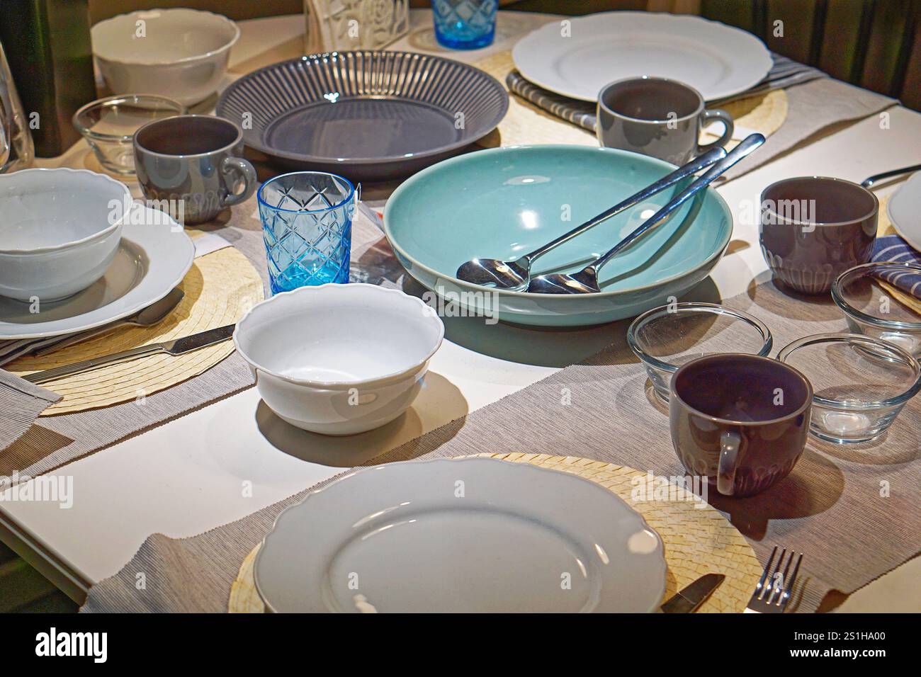 Ceramic dishes and bowlswith mugs at modern dining table top setup ...