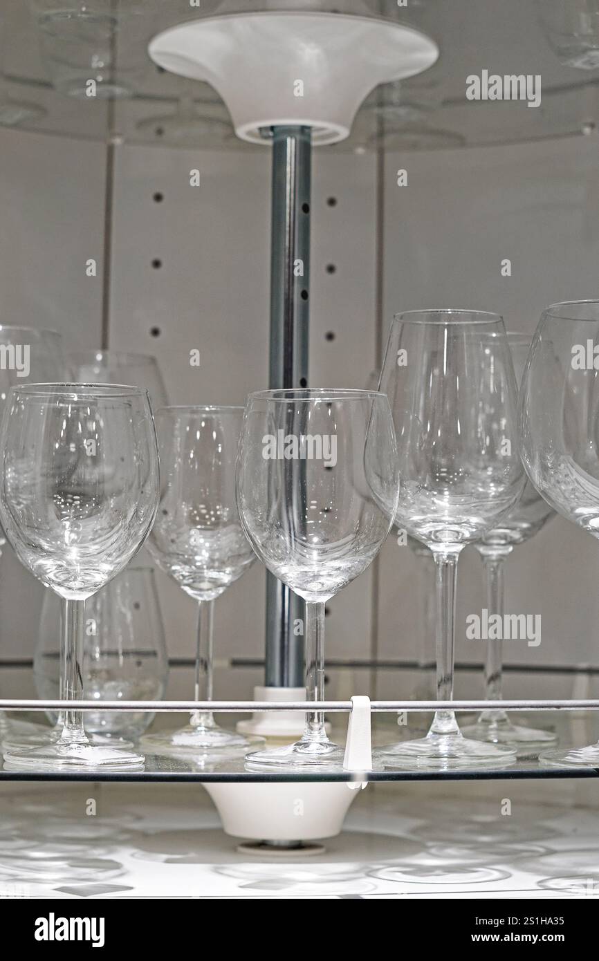 Wine glasses at rotating glass shelf in kitchen cabinet Stock Photo - Alamy