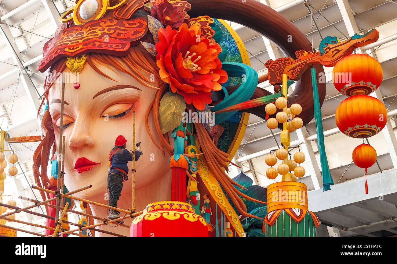 A worker adds the final touch to a large lantern of a goddess under ...