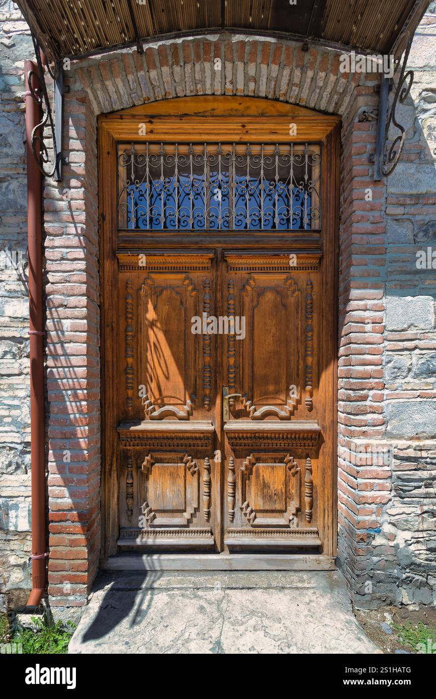 A beautifully crafted wooden door showcases intricate carvings, framed ...