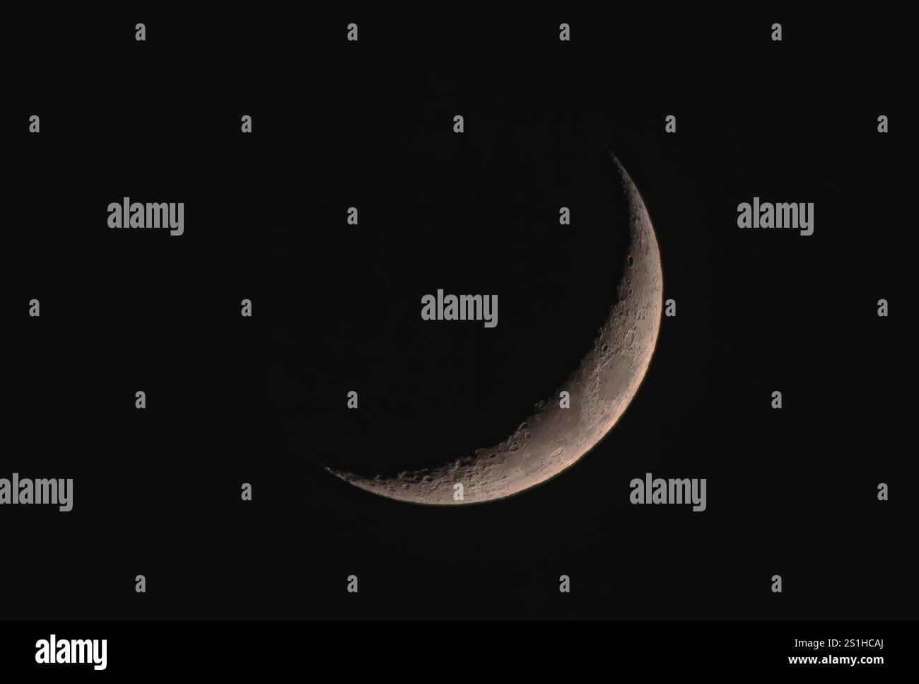 A close-up view of a crescent moon showcasing detailed craters and ...