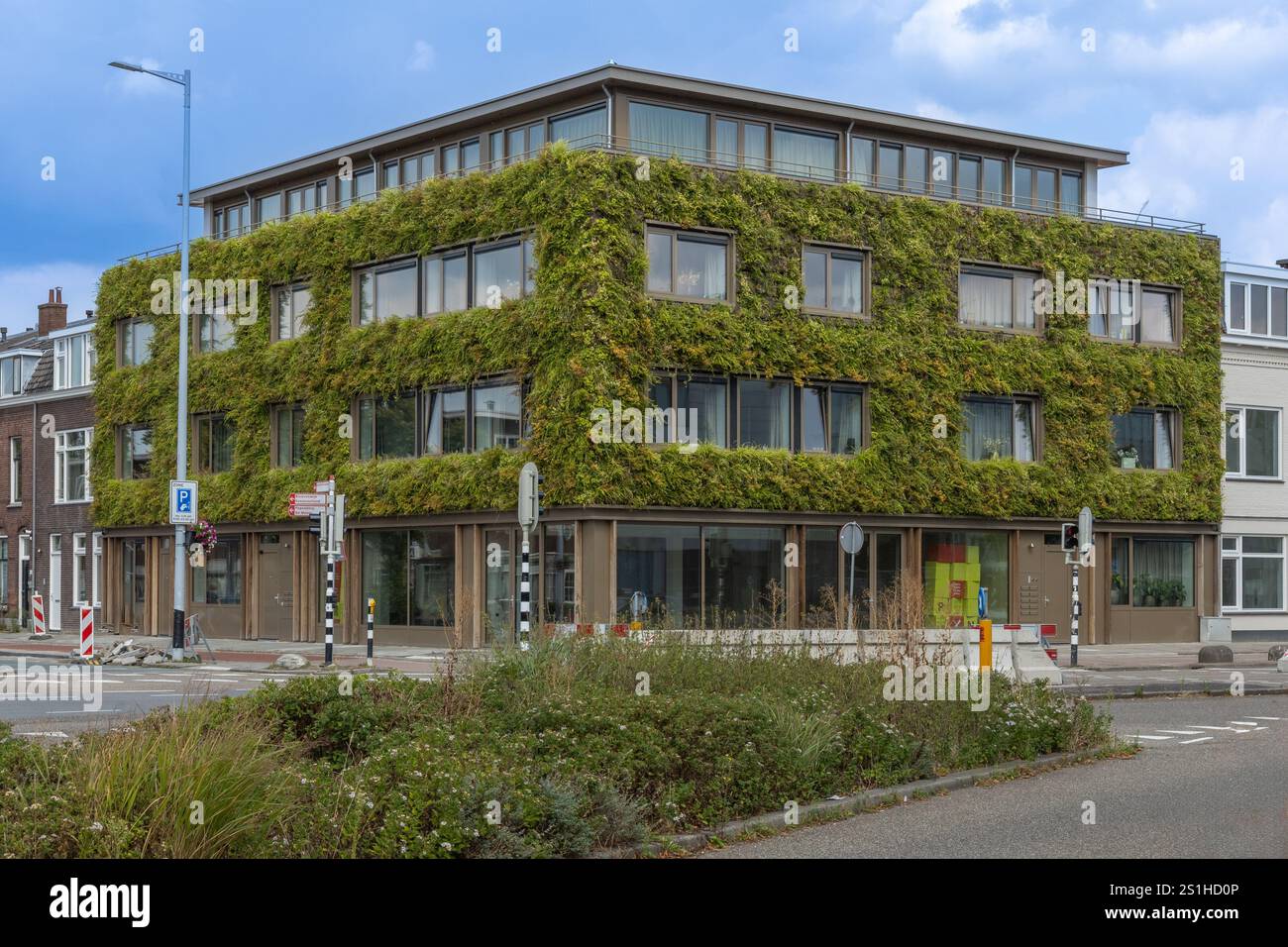 Modern green building with the facade completely covered with plants ...