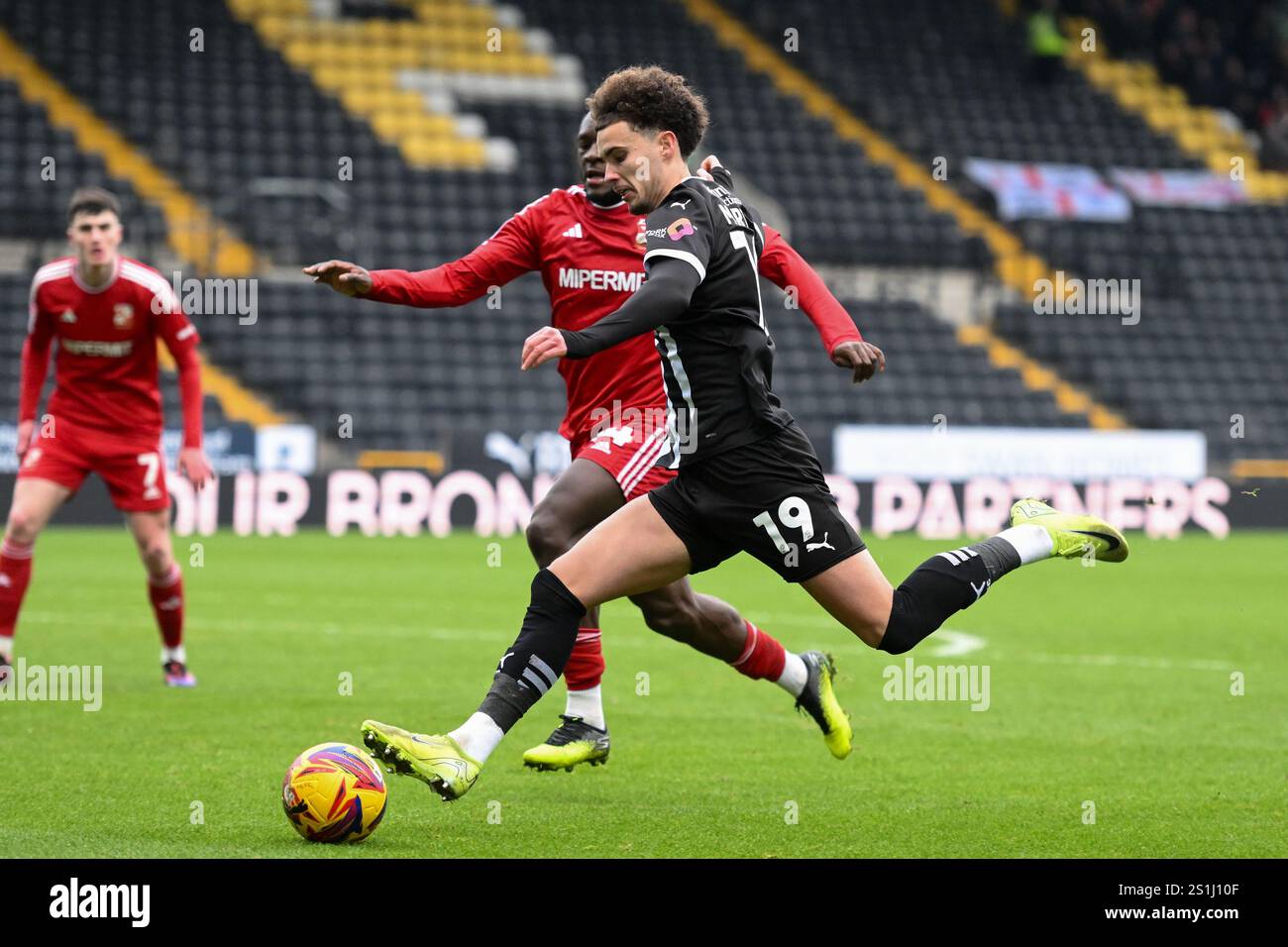 Josh Martin of Notts County lines up a cross under pressure from Rosaire Longelo-Mbule of ...