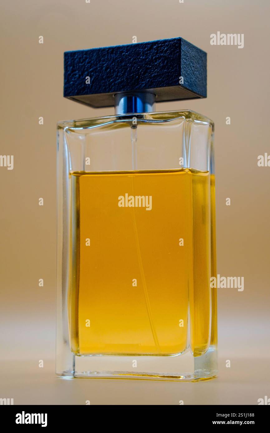 Perfume mockup bottle with a black textured cap and amber liquid inside ...