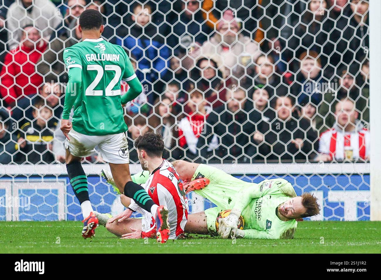 #21, goalkeeper Conor Hazard of Plymouth Argyle (right) makes the save ...