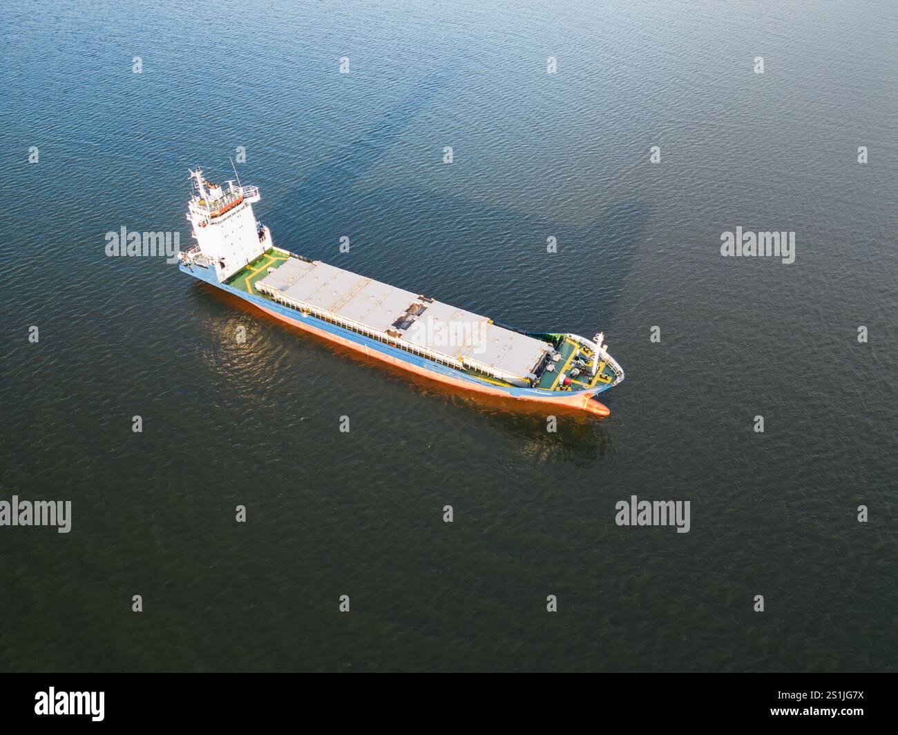 A drone's eye view of an empty cargo ship sailing the calm sea after ...