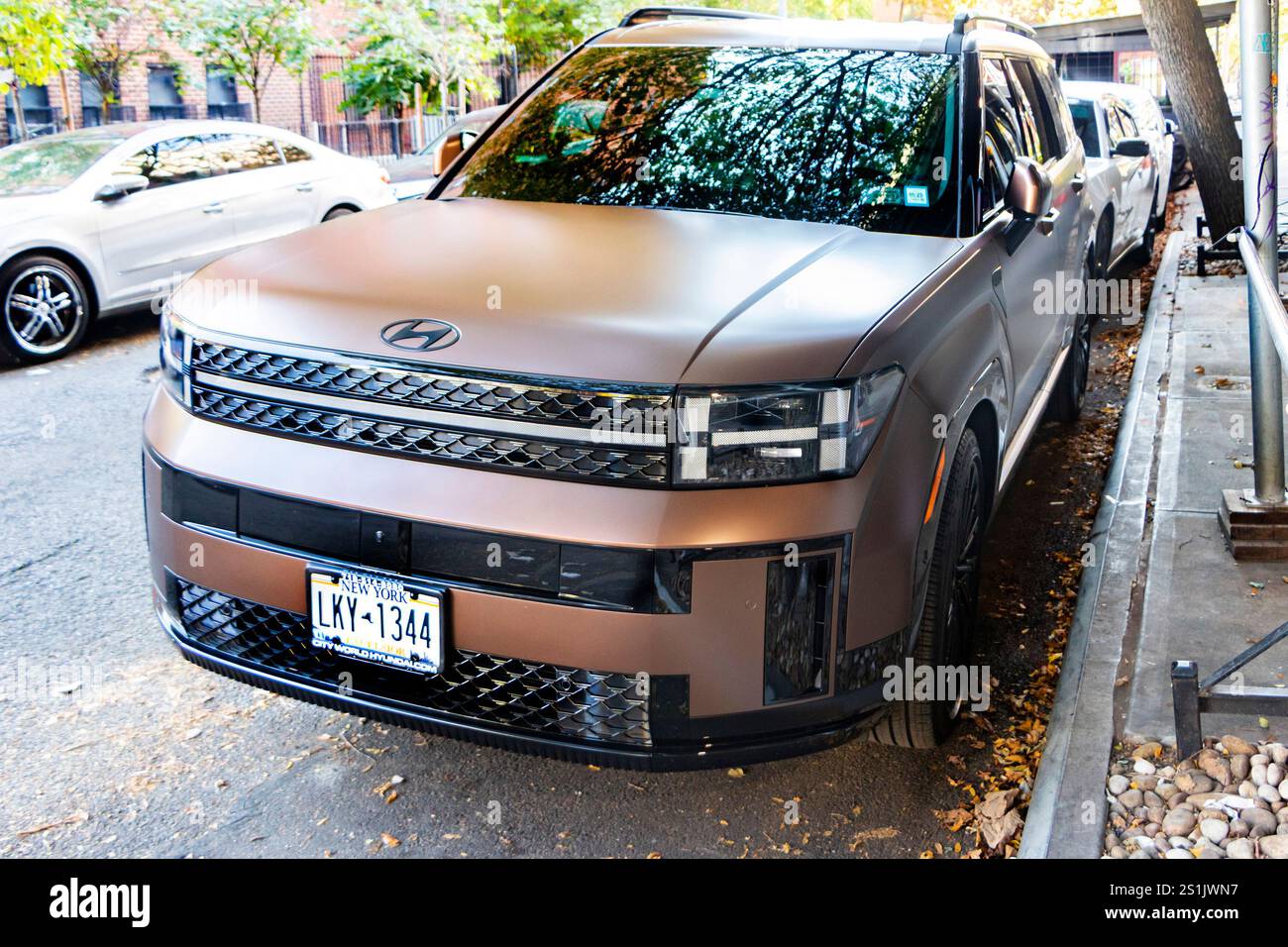 A new bronze Hyundai santa fe XRT hybrid SUV parked on an urban street ...