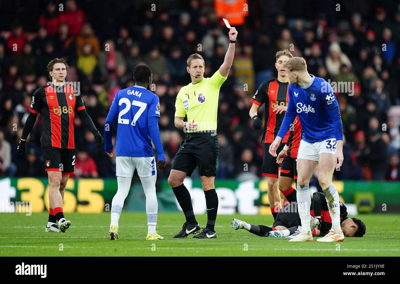 Referee John Brooks shows a yellow card to Everton's Jarrad Branthwaite ...