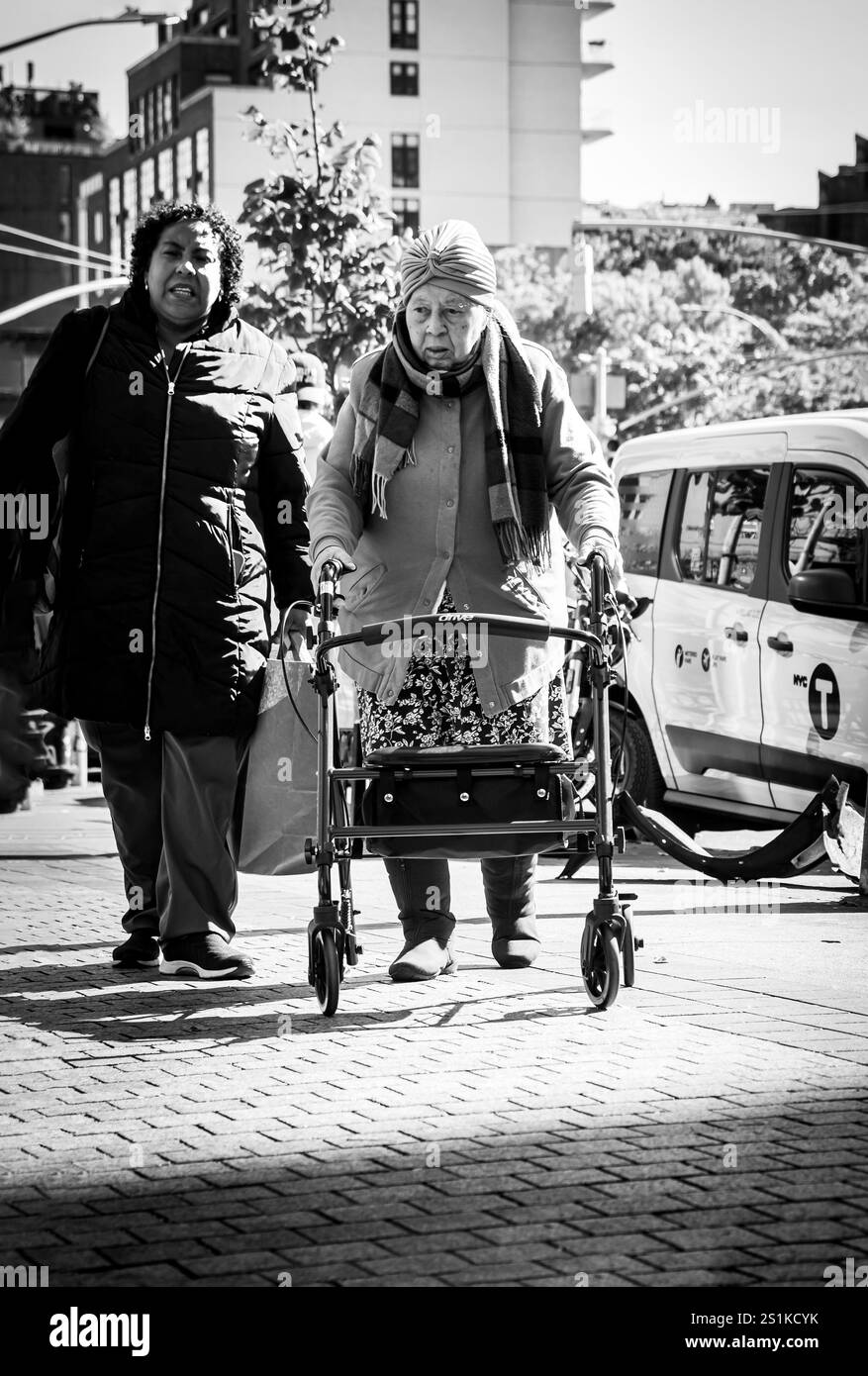 elderly asian woman in chinatown lower east side walks with walker or ...