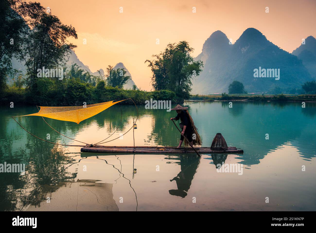 Fisherman villager with traditional fishing on bamboo raft over the ...