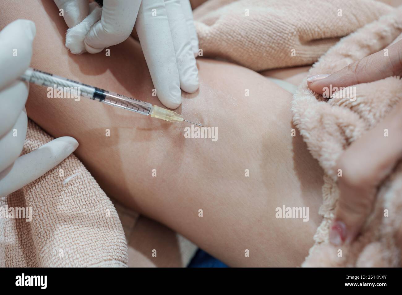 Closeup of medical specialist administering an injection with syringe ...