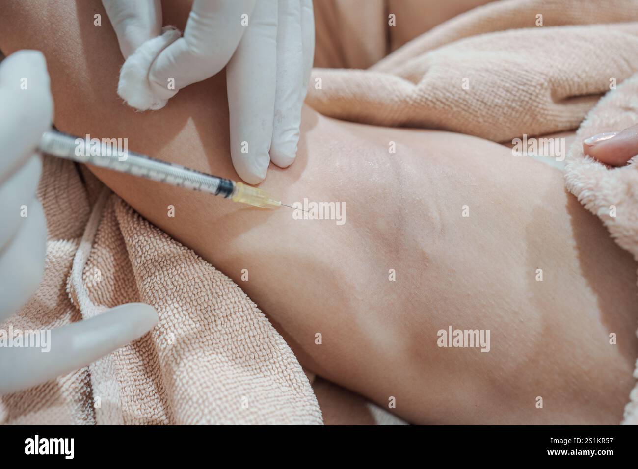 Closeup of medical specialist administering an injection with syringe ...