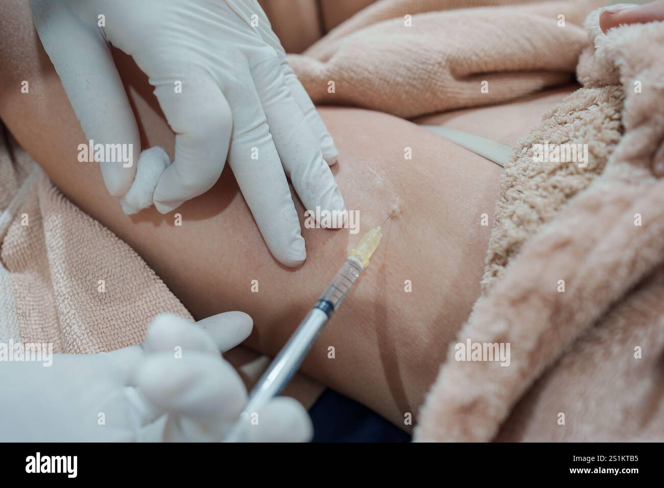 Closeup of medical specialist administering an injection with syringe ...