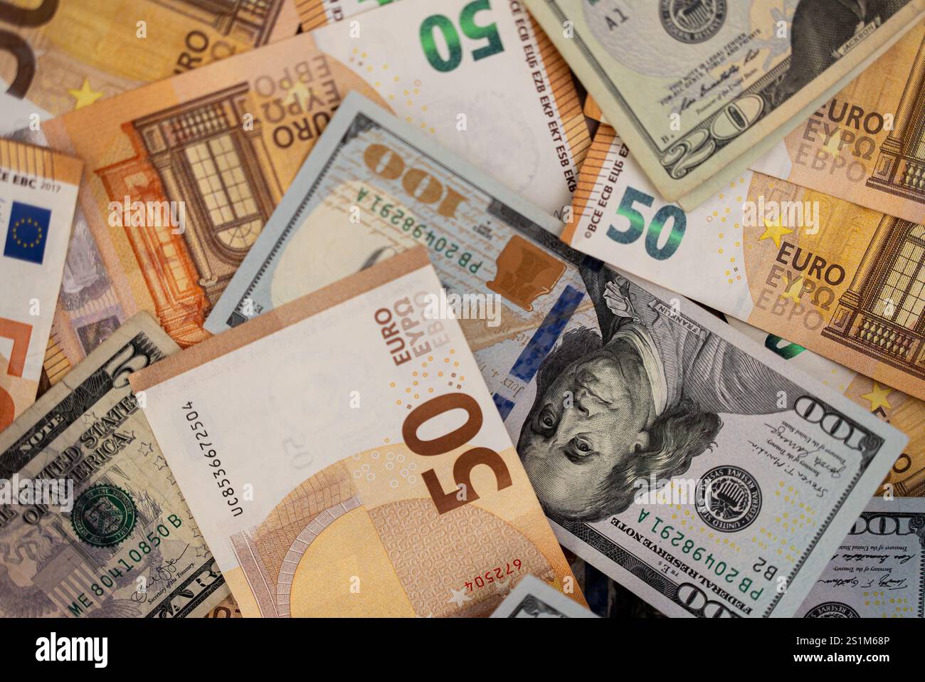 Mixed Euro and US dollar banknotes spread out in a detailed close-up ...