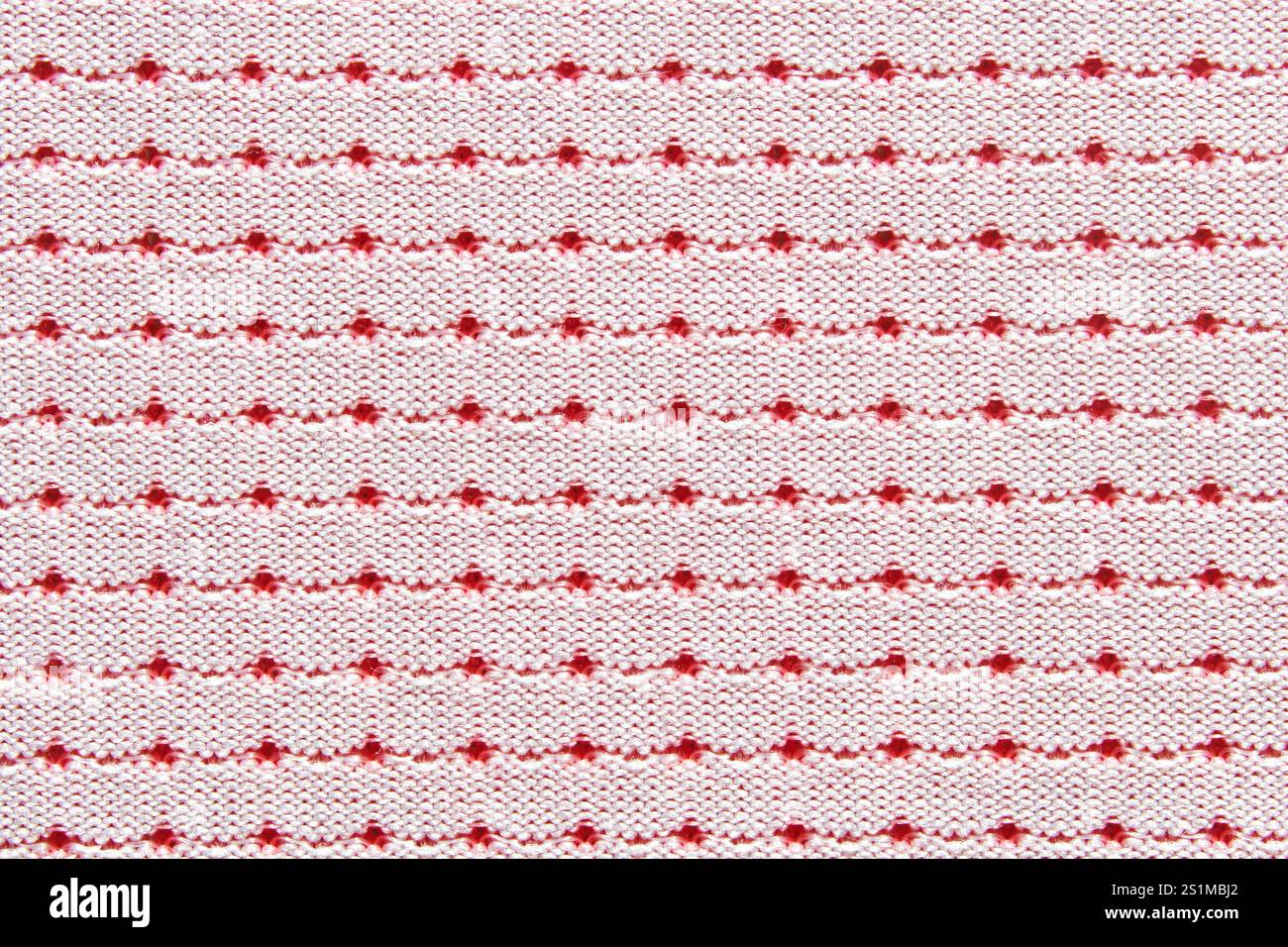Red and white dotted pattern on knitted fabric background with ...