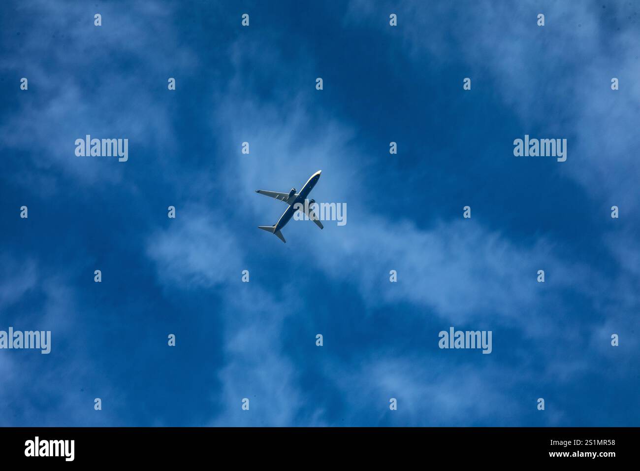 An Airplane is Flying Gracefully through a Beautiful Blue Sky Filled ...