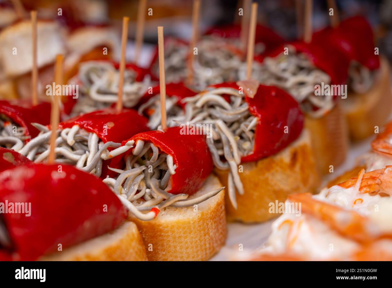 Typical snack of Basque Country, pinchos or pinxtos skewers with small ...
