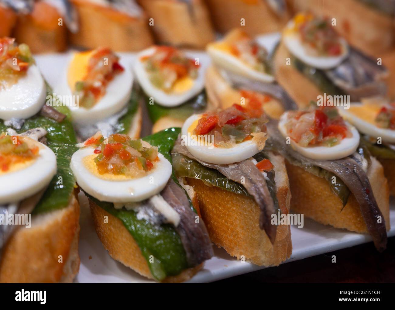 Typical snack of Basque Country, pinchos or pinxtos skewers with small ...