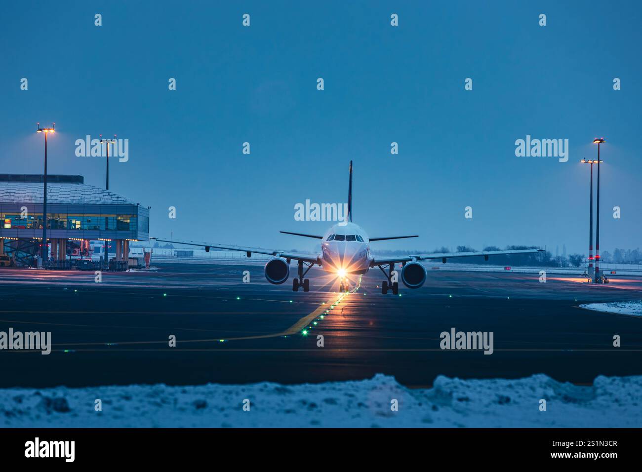 Traffic at airport at night. Front view of passenger airplane taxiing ...