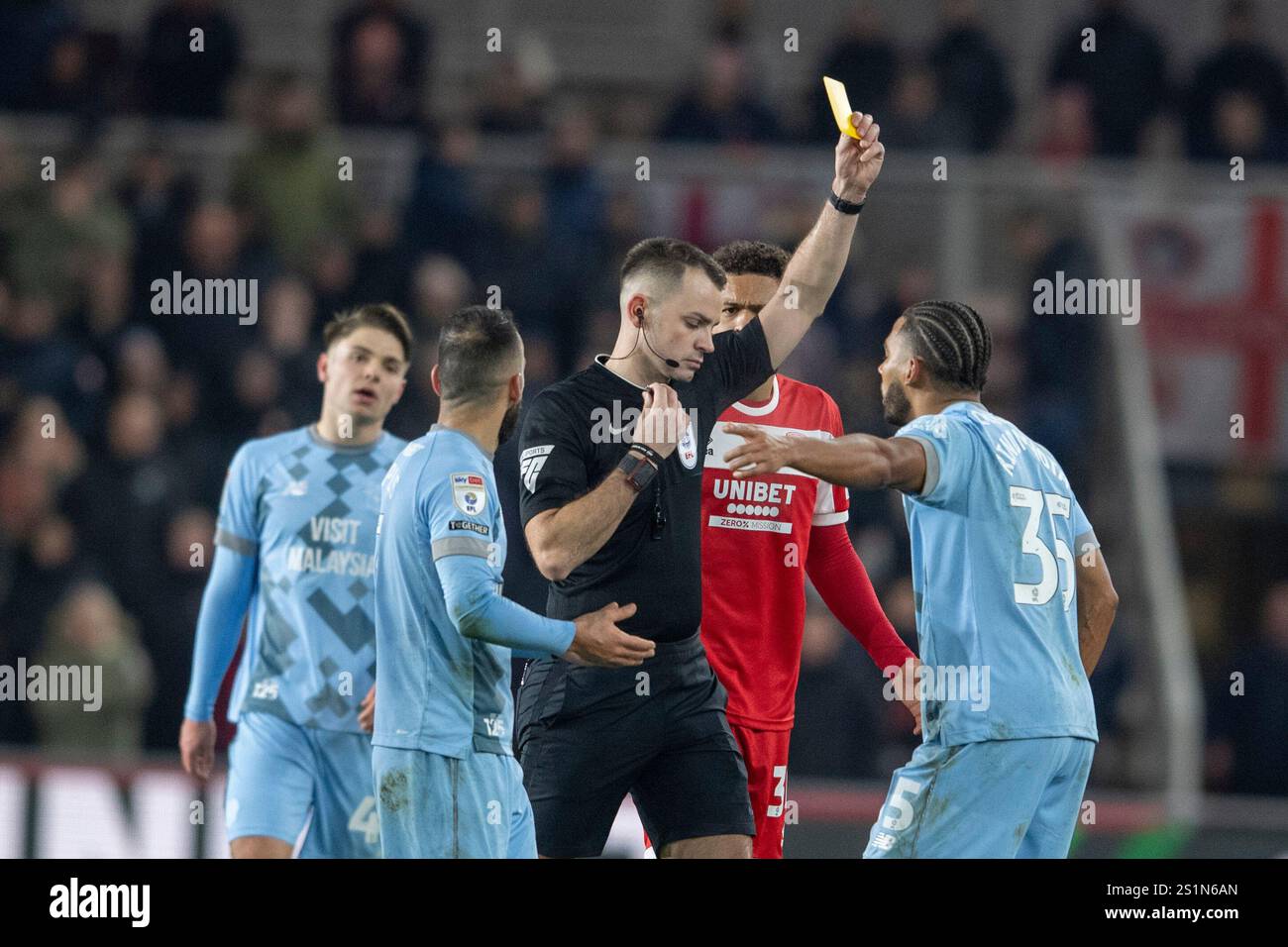 Referee Tom Nield shows Cardiff City's Andy Rinomhota the yellow card ...