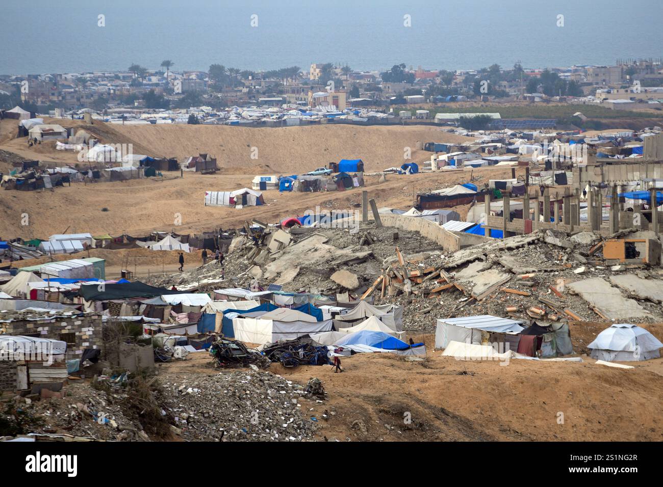A tent camp for displaced Palestinians is set up amid destroyed ...