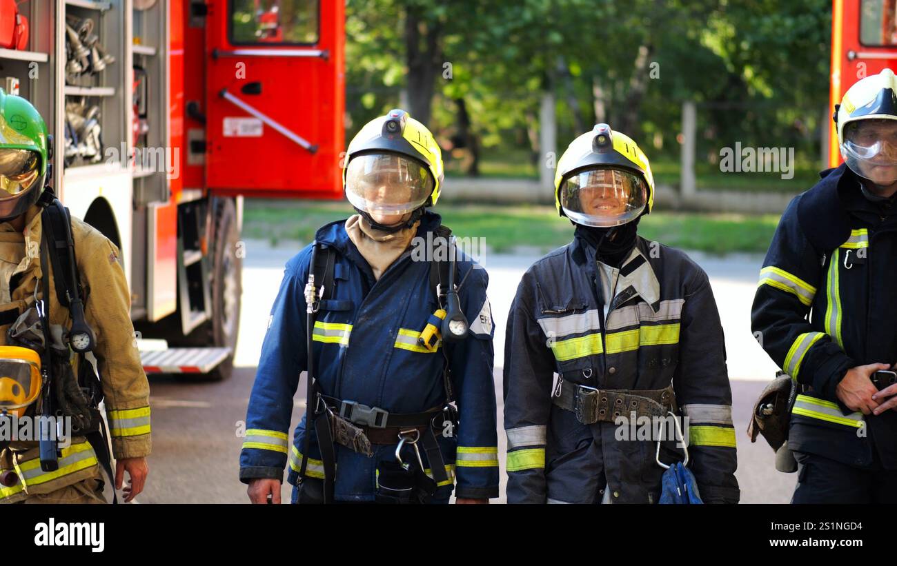 Portrait of male and female firefighters in helmets and protective ...