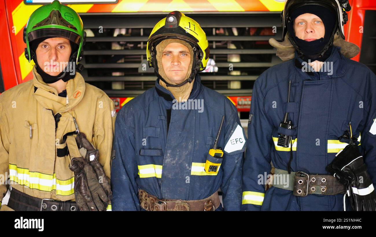 Portrait of male firefighters in helmets and protective uniforms ...