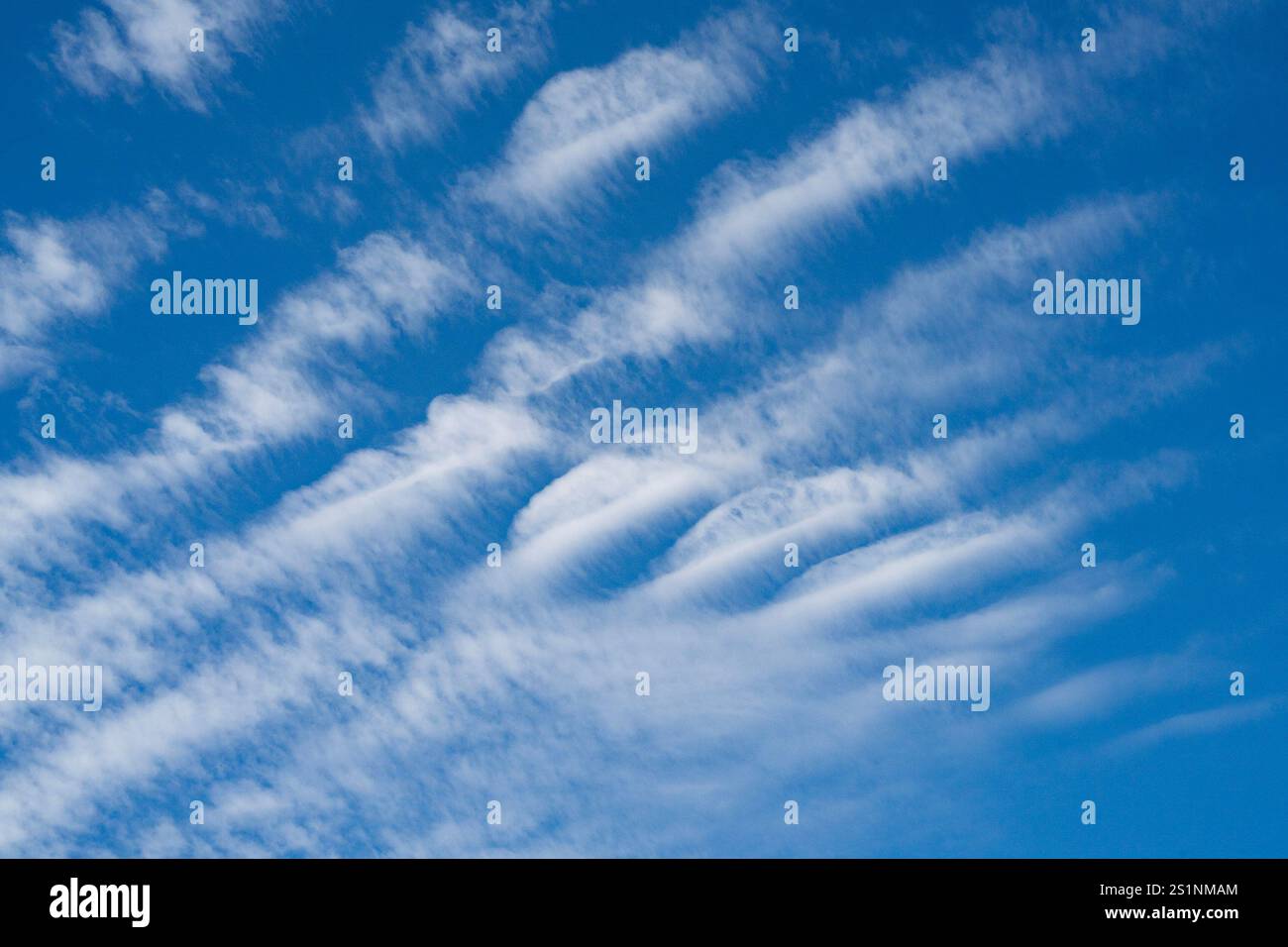 A blue sky with thin, wispy clouds arranged in parallel lines Stock ...