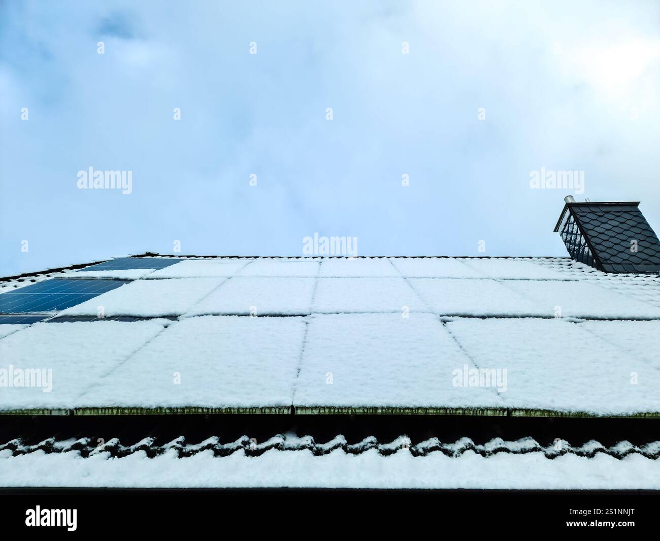 A roof with many solar cells that are almost completely covered in snow ...