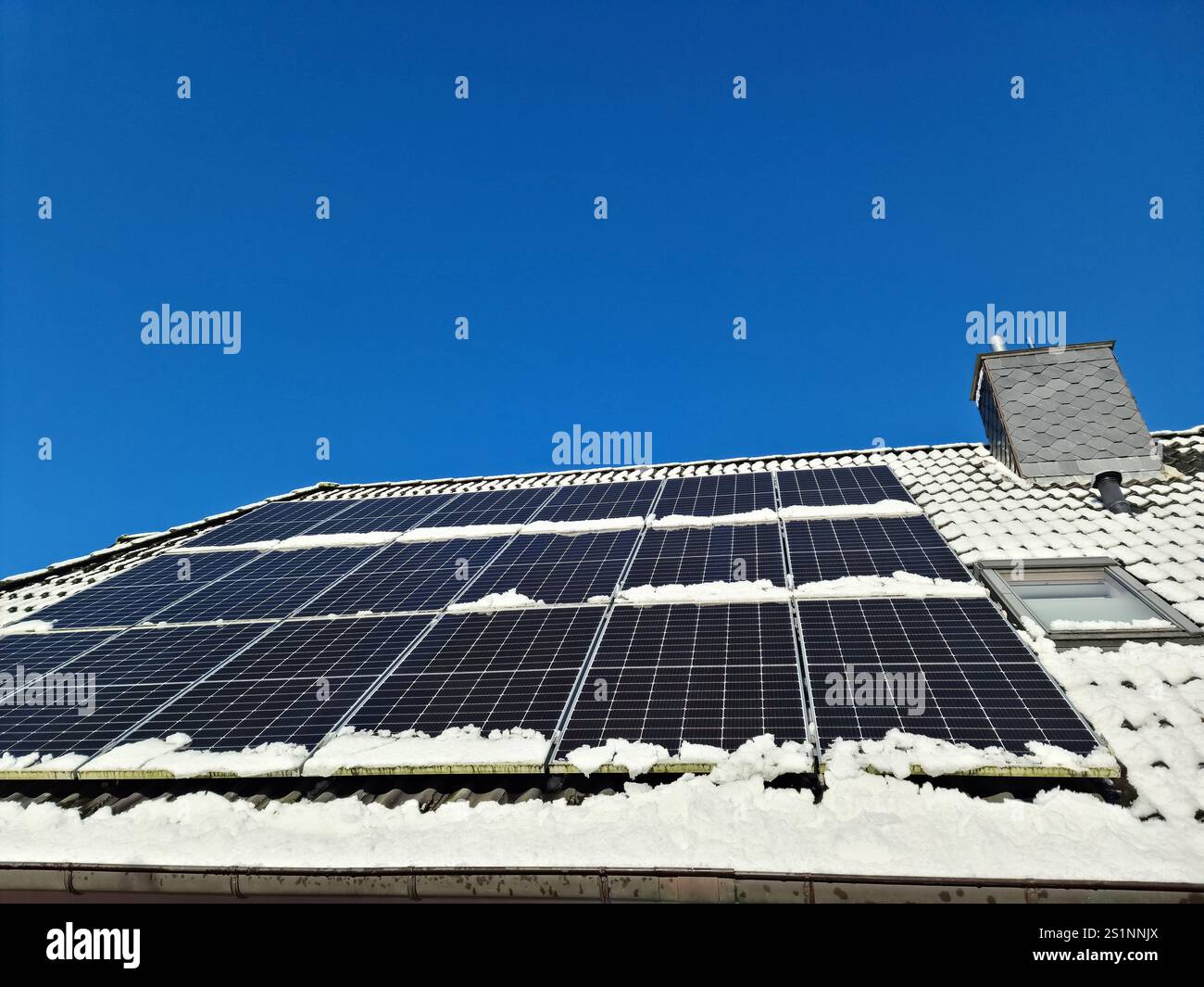 View of a roof with many solar cells in winter with some snow and ice ...