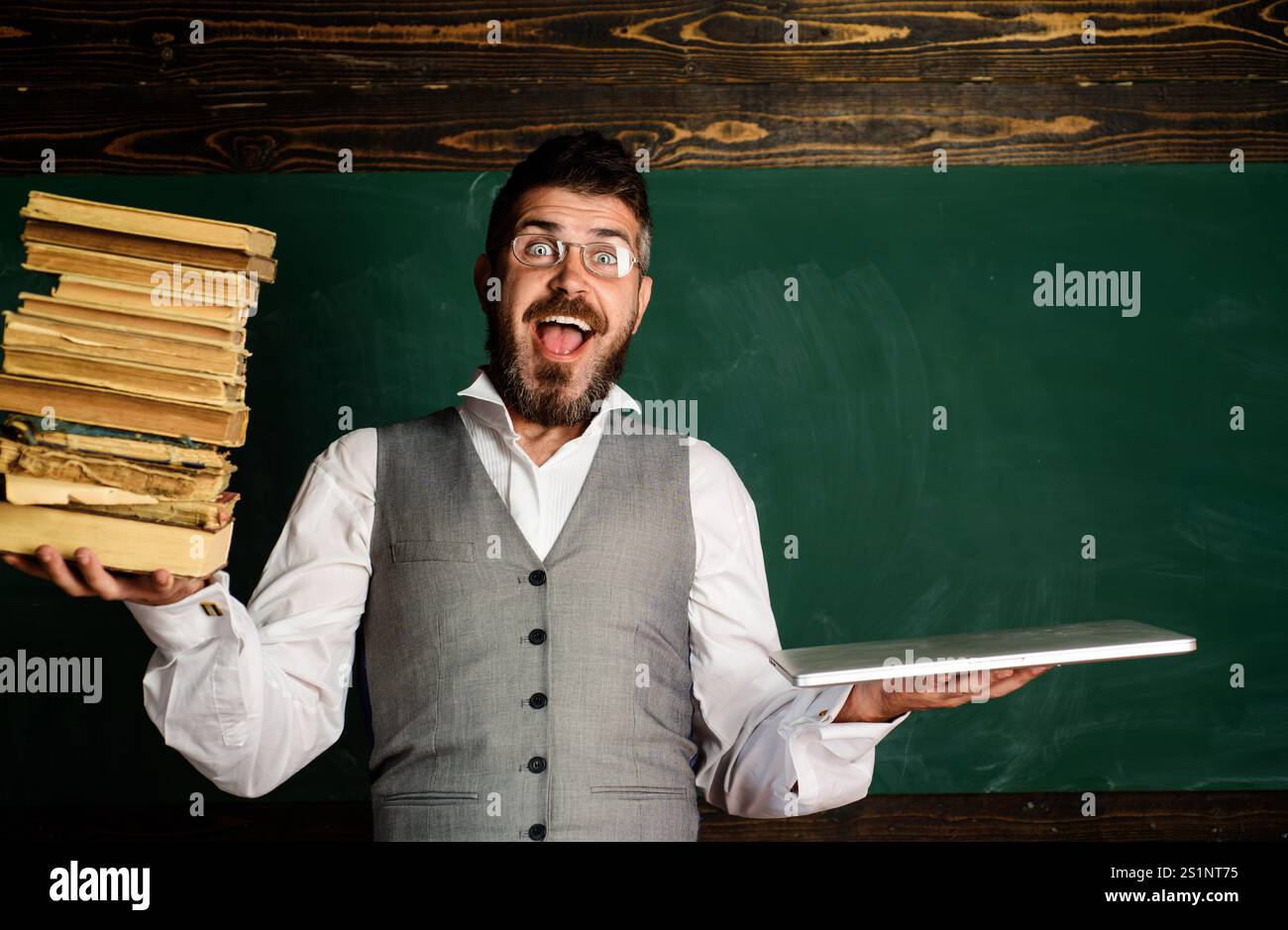 Happy student with pile of traditional textbooks and laptop in ...
