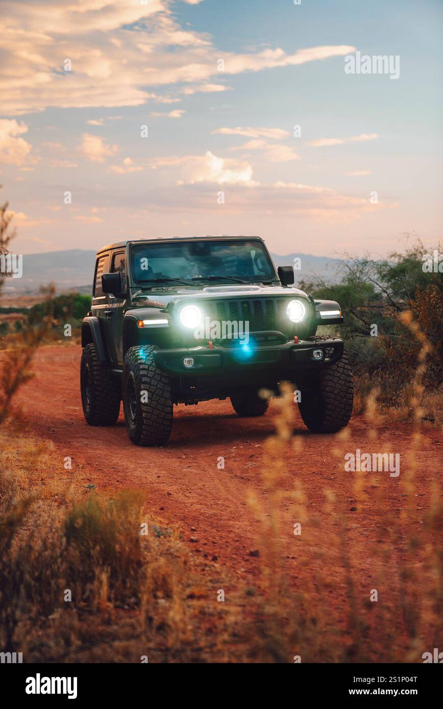 A rugged Jeep Wrangler conquering a dusty trail under a vibrant desert ...