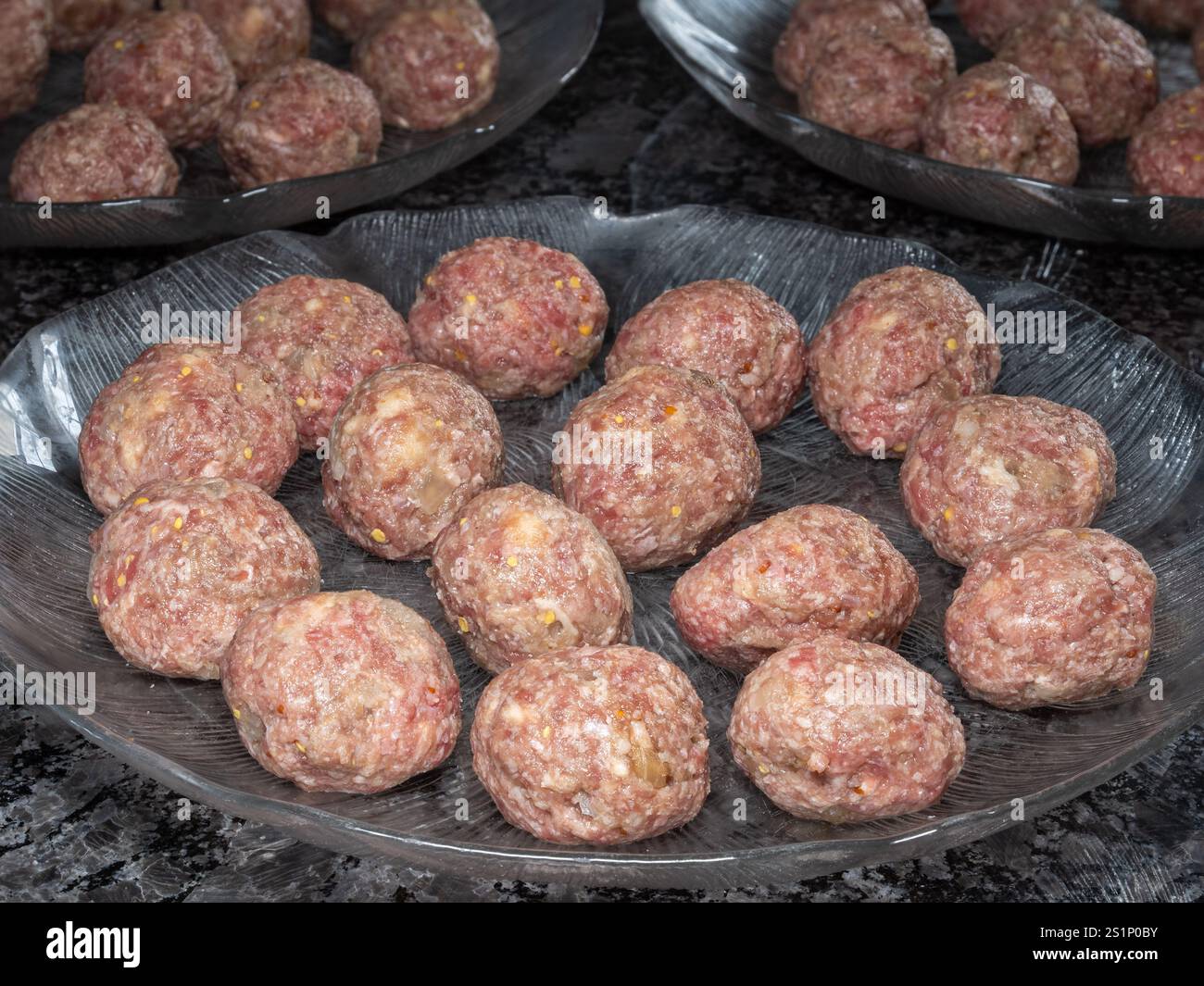 Traditional Swedish meatballs, uncooked and carefully prepared, sit on ...