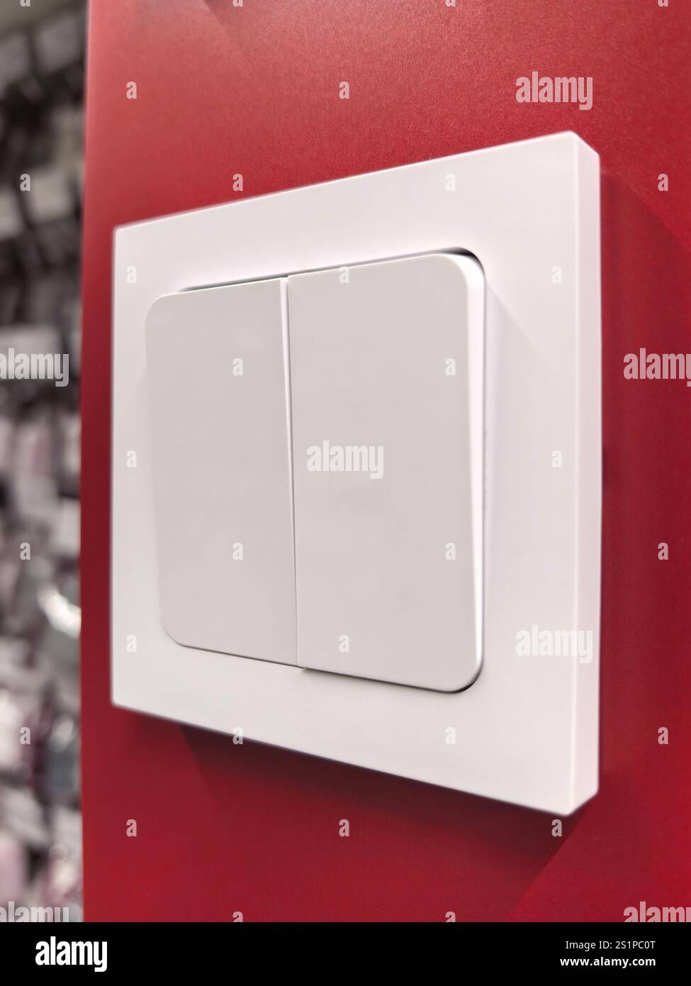 A sleek, minimalistic light switch is mounted on a bright red wall. The ...