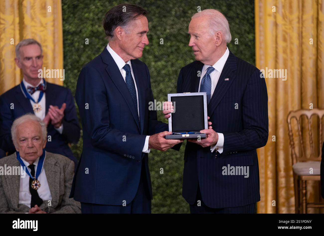 President Joe Biden presents former governor Mitt Romney, son of ...