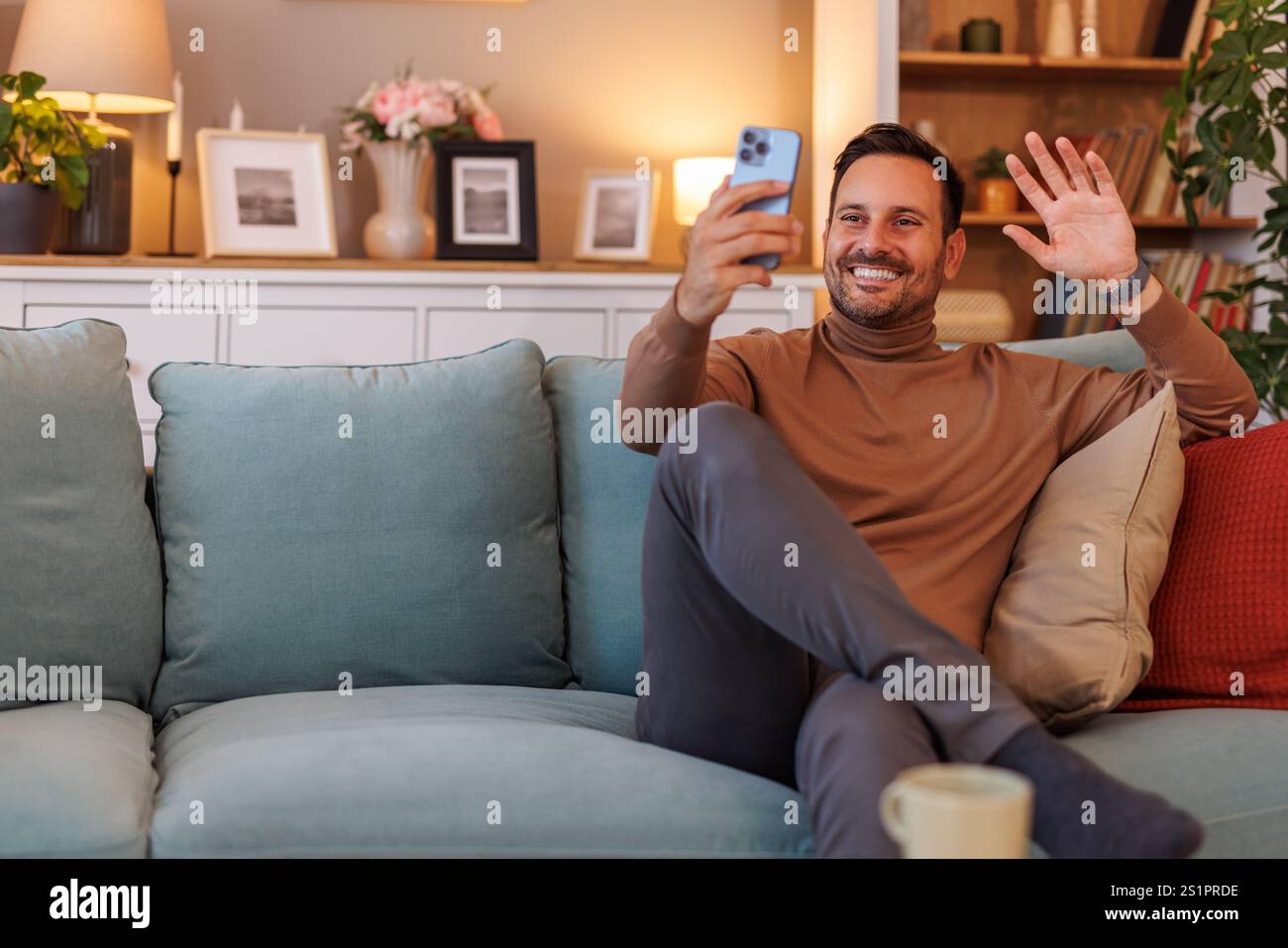 Portrait of cheerful businessman waving hand and greeting while talking ...