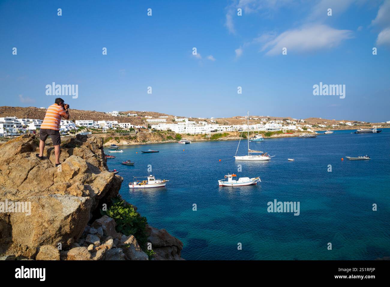 Man on Scenic Rocky Clifftop Overlooking Calm Blue Coastal Waters and ...