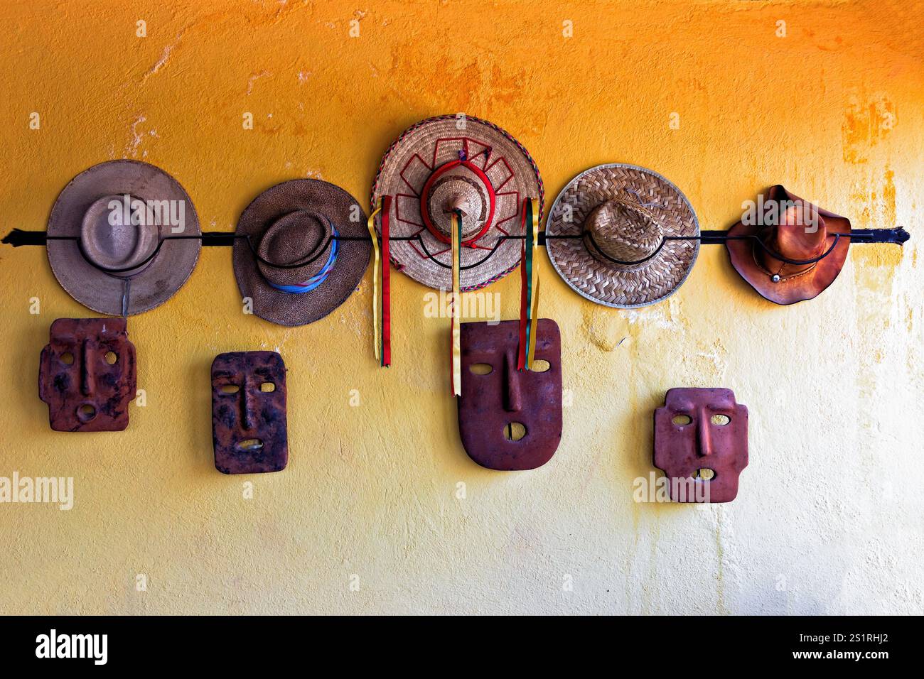 Collection of Rustic Hats and Decorative Masks on Vibrant Yellow Wall ...