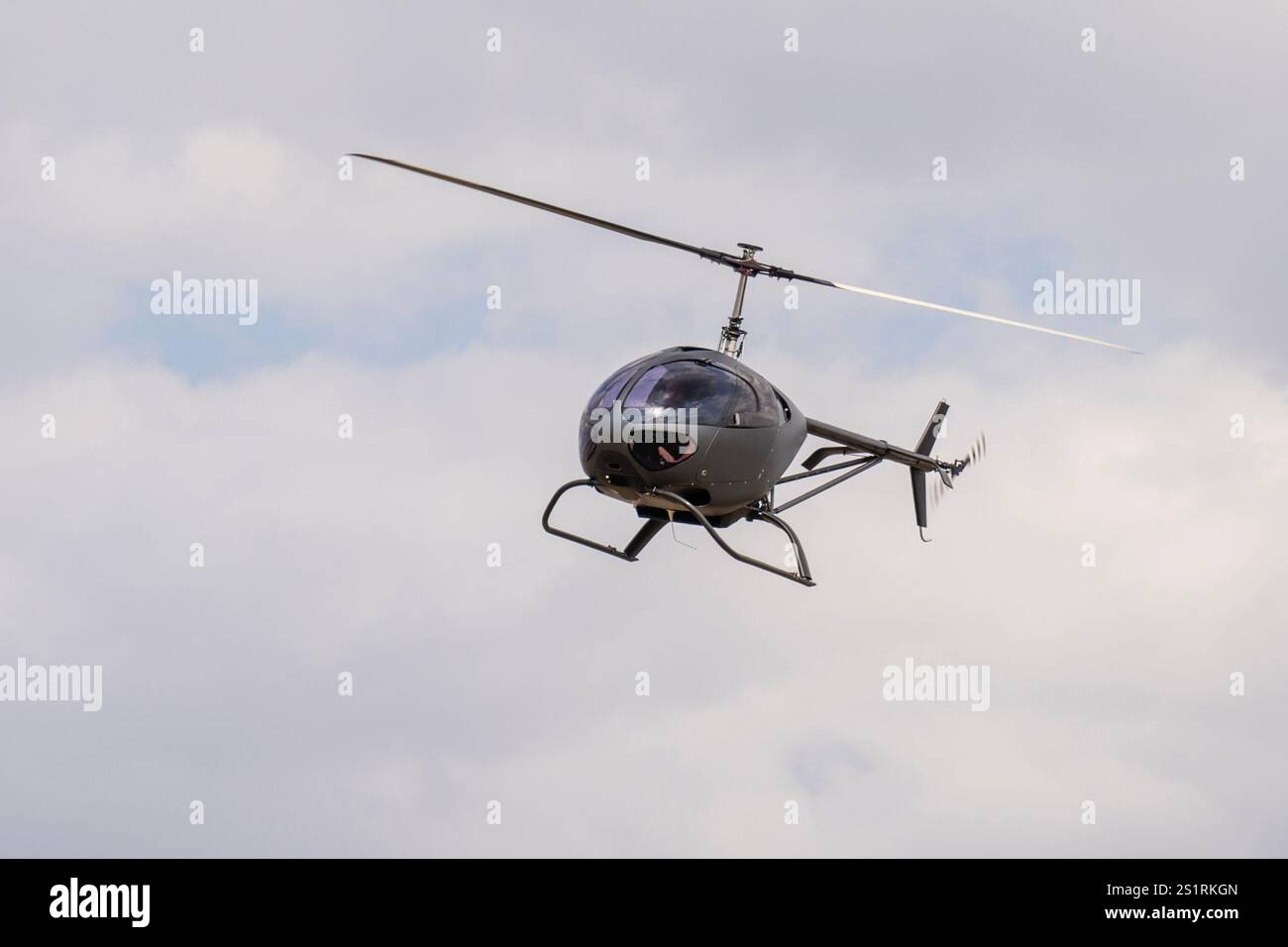 Modern gray two-seater small helicopter flying in the air Stock Photo ...