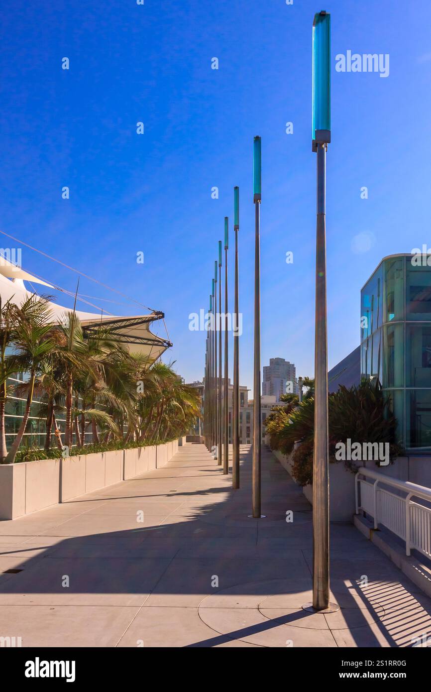 A long walkway with a blue sky above and palm trees in the background ...