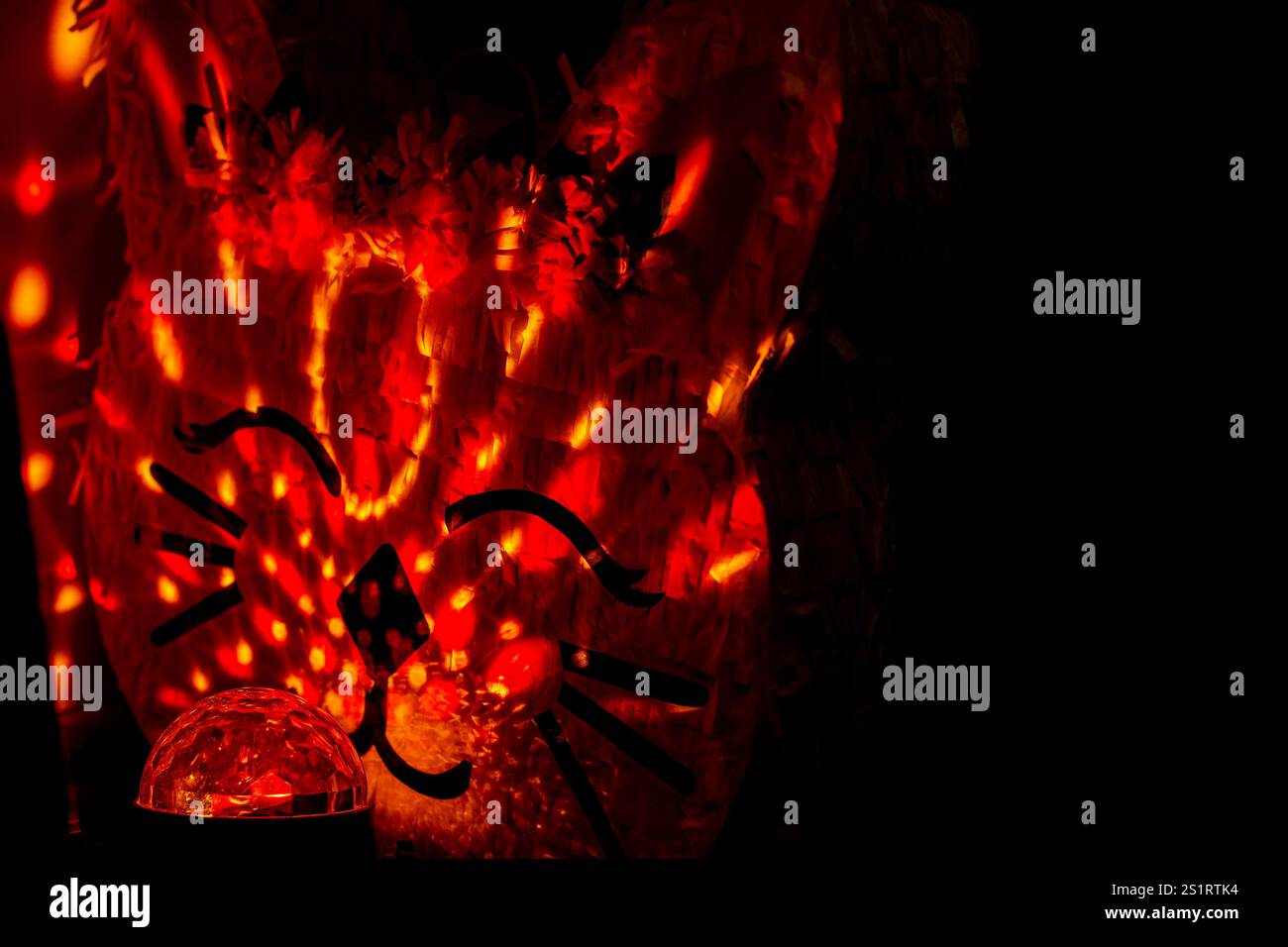 Cat Face Pinata Decoration Illuminated by Red Lights on Black ...