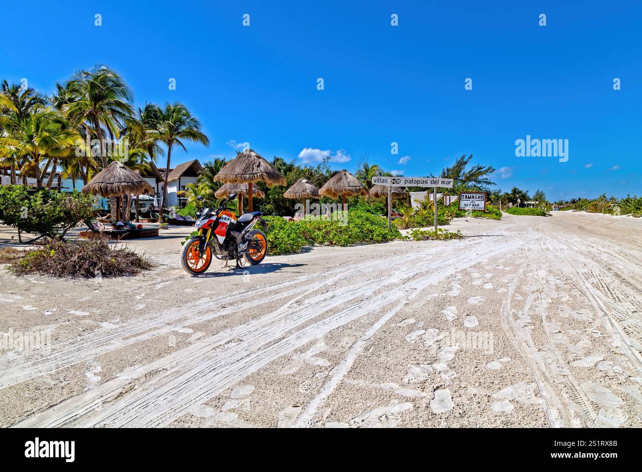 Motorcycle on a Tropical Sandy Beach with Palm Trees and Small Huts ...