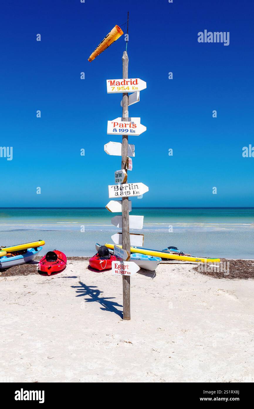 Wooden Directional Signpost on Sandy Beach with Kayaks and Blue Sea ...
