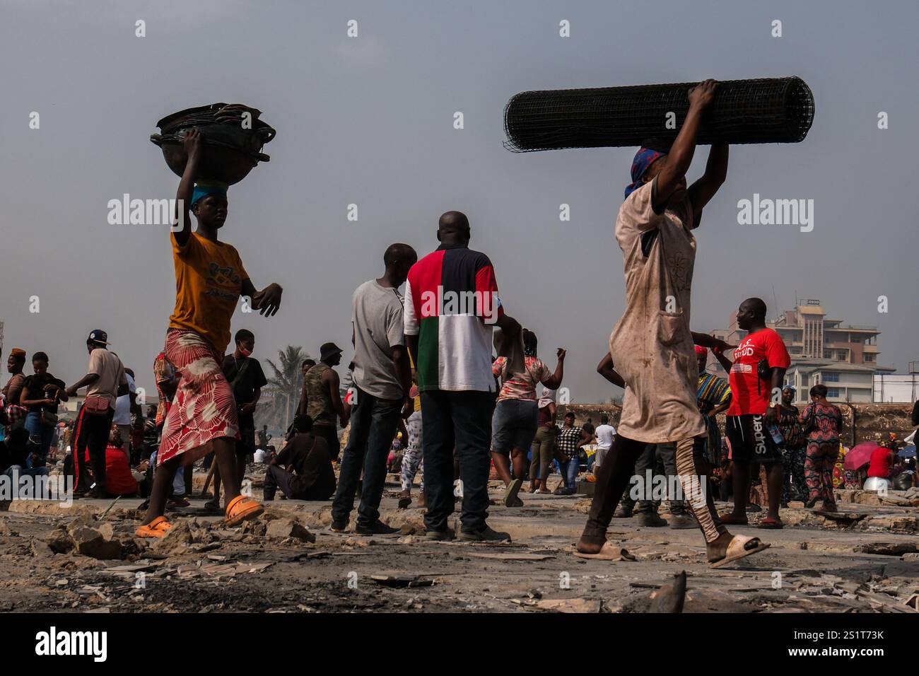 Accra, Accra, Ghana. 4th Jan, 2025. Women carry burnt pans on her head ...