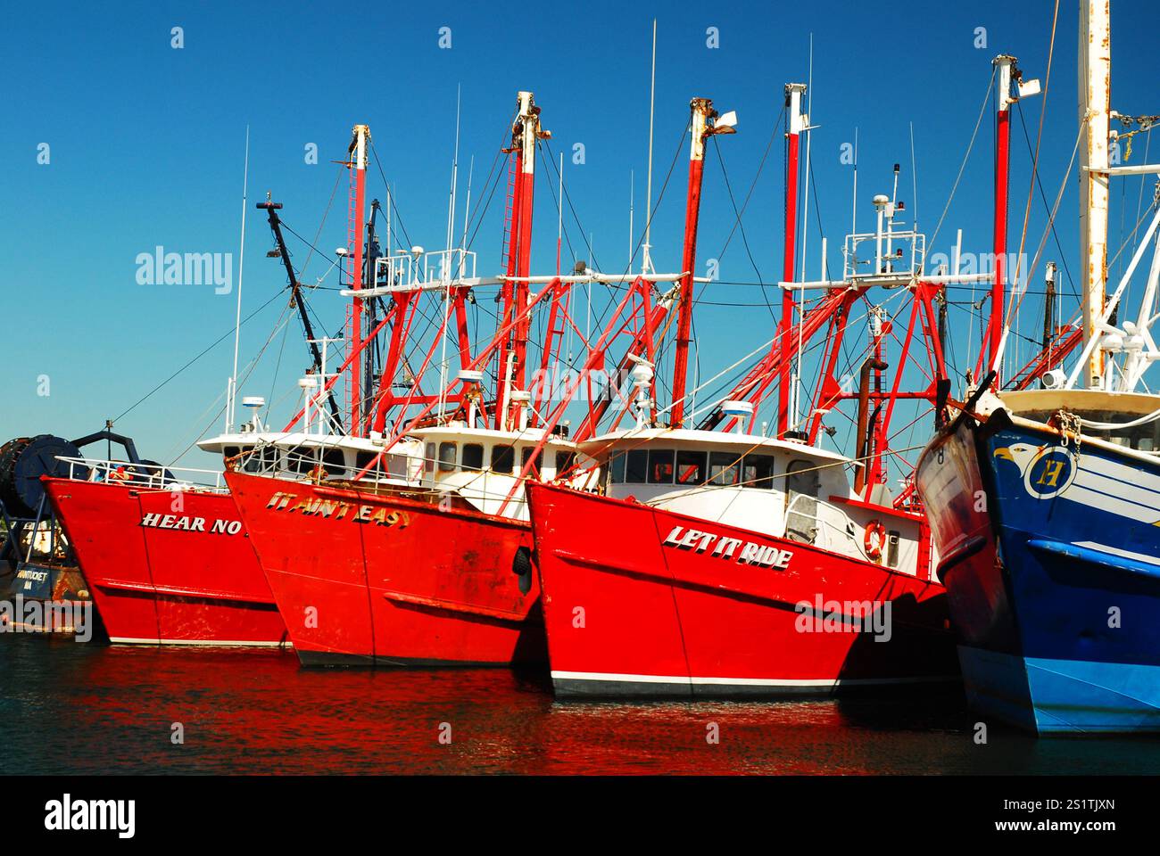 Large red fishing boats are docked at the harbor of New Bedford ...