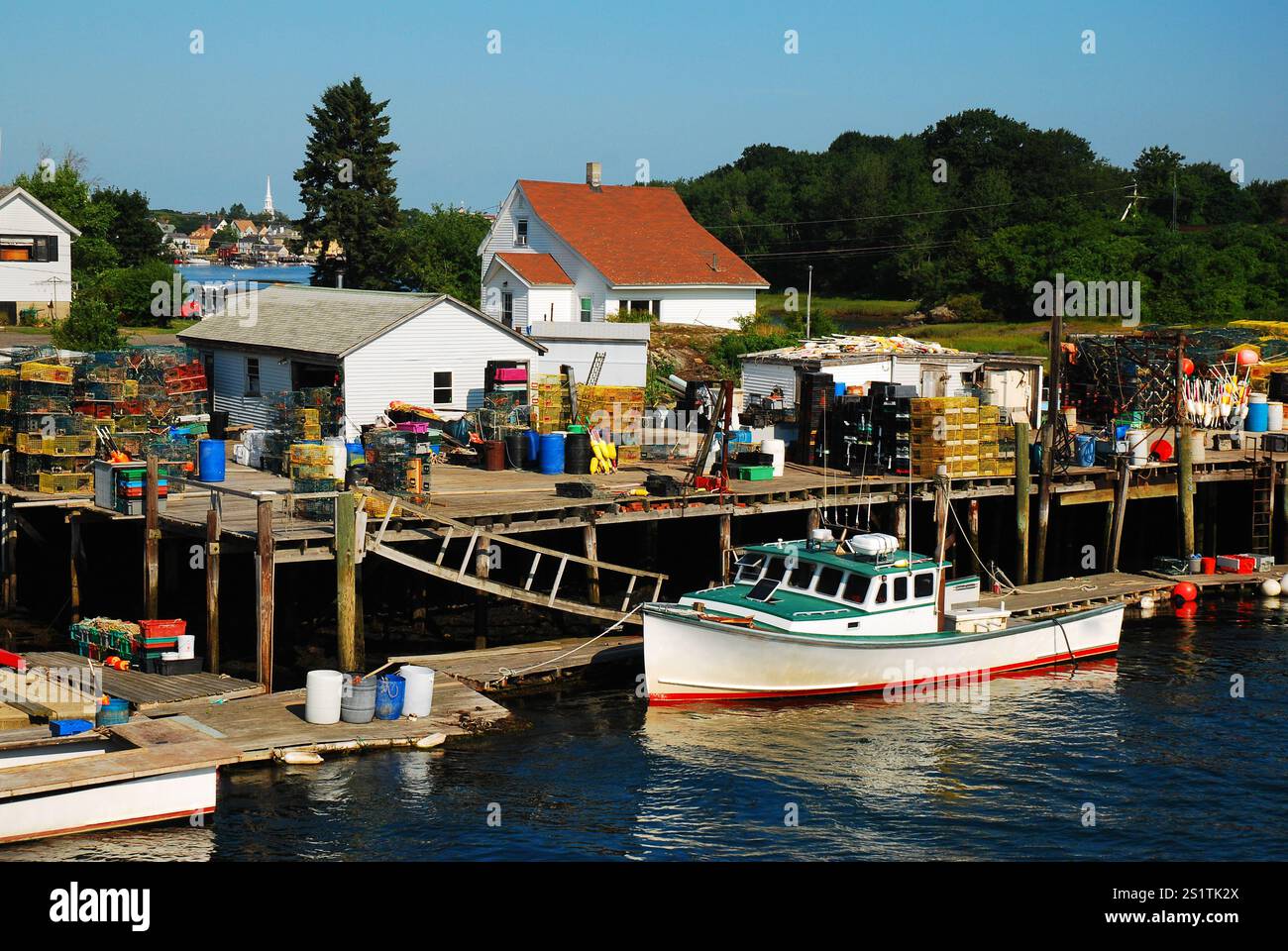 A working lobster and fishing dock sits calmly in the early morning in ...