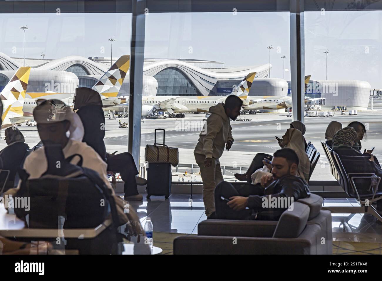 Abu Dhabi Airport. View of the modern terminal with Etihad airline aircraft from the gate. Abu ...